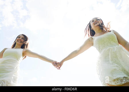 Two happy young women hand in hand on the beach Stock Photo - Alamy