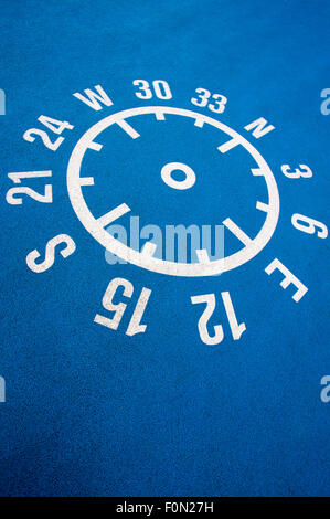White shape of compass printed with coordinates and numbers on a blue ...