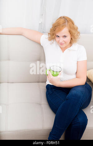 Young plus size woman drinking glass of cola beverage screaming proud ...