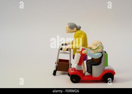 Elderly male and female toy/cartoon figures on neutral background ...