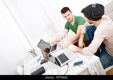 Two workmates teaming up and working together Stock Photo - Alamy