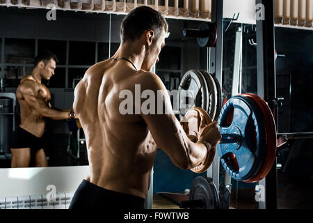 very power athletic guy , execute exercise with dumbbells, in gym Stock ...