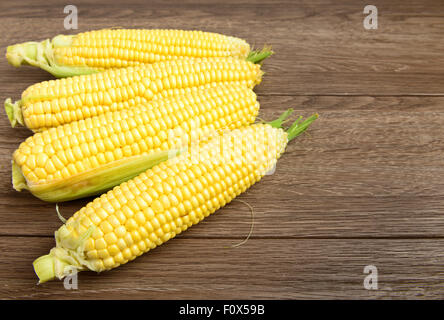 Fresh raw corn cobs on wooden background. Raw corn with skin. Sweet ...