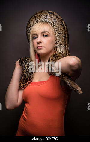 Young girl with a snake wrapped around her pulling a funny face Circa ...