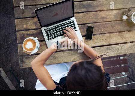 Me time is screen time. Shot of a young woman using a laptop at home ...