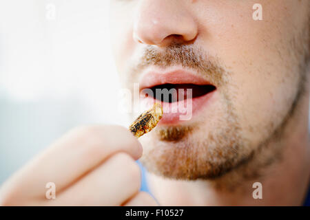 MAN EATING INSECT Stock Photo - Alamy