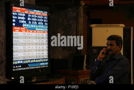 Karachi. 24th Aug, 2015. A Pakistani stockbroker watches share prices ...