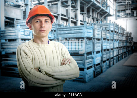 Workman in big storage room with metal boxes in factory Stock Photo - Alamy