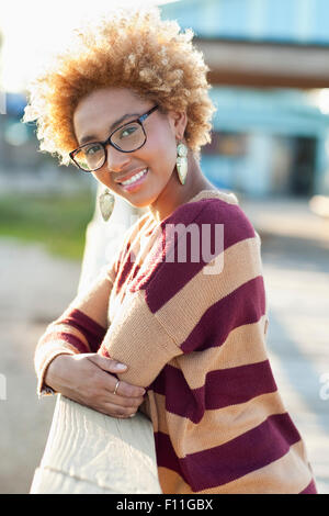 Blond woman leaning on black wall Stock Photo - Alamy
