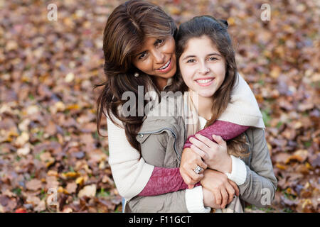 Smiling woman hugging friend at autumn park Stock Photo - Alamy