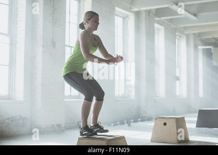 Athlete jumping on platform in gym Stock Photo - Alamy