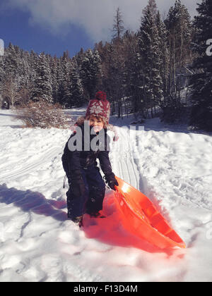 Smiling cute boy on snow covered land while snowing during winter Stock ...
