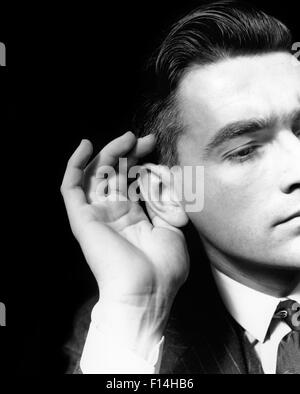 Portrait of adult man eavesdrop with hearing gesture listen shock news ...