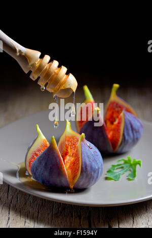 Fresh ripe half figs and honey for dessert Stock Photo - Alamy