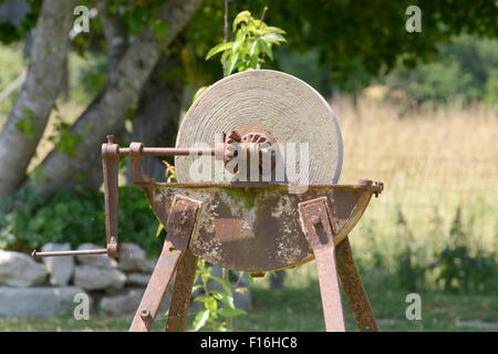 Circular sharpening stone with handle used to sharpen agricultural ...