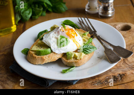 Eating toast with avocado and poached egg in a cafe Stock Photo - Alamy