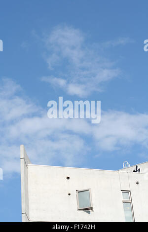 The top corner of a modern concrete building on cloudy sky background ...