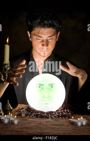 Young man in halloween wizard costume standing in dark forest with ...