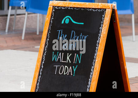 "The Doctor is In" sign in front of neighborhood medical care facility ...