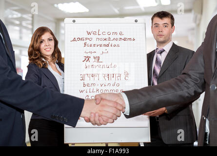 Two young corporate trainers welcome participants of the training Stock ...