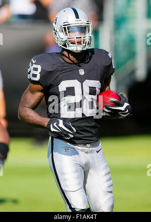 Oakland Raiders running back Latavius Murray (28) is tripped up by ...
