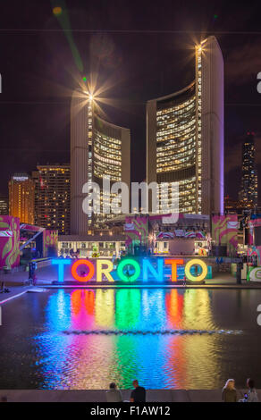Toronto Sign with the illuminated City Hall at night, in Toronto ...