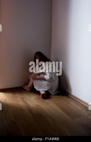 Scared girl sitting in the corner Stock Photo: 172528564 - Alamy