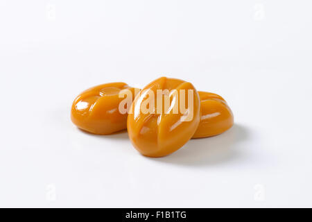 three caramel candies on white background Stock Photo - Alamy