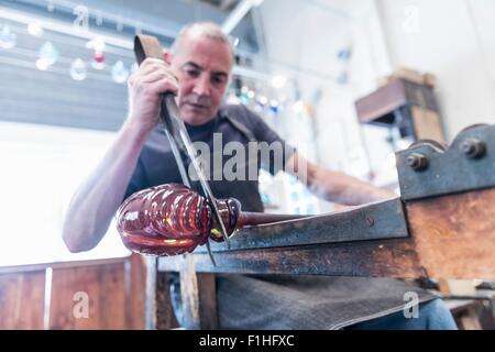 Glassblower blowing hot glass Stock Photo - Alamy
