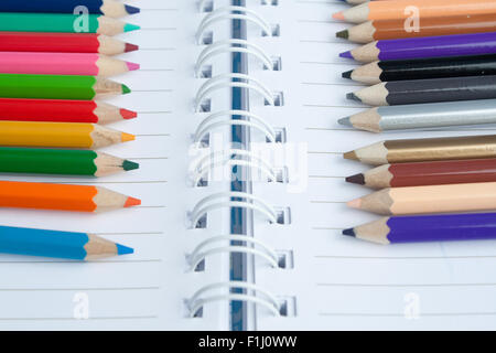 Note book and colored pencils Stock Photo - Alamy