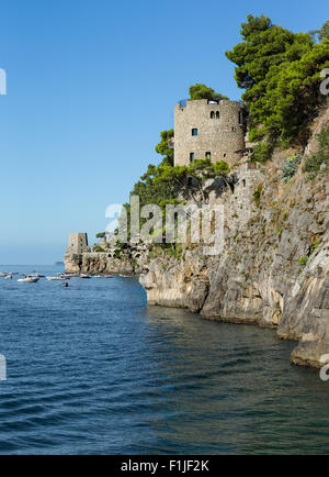 The vertical view of the sea watchtower in the water under the blue sky ...