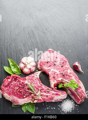 Raw beef steaks, with herbs, on wooden table. Concept of food cooking ...