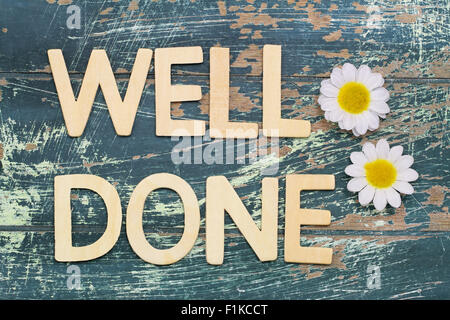 Well done written with wooden letters on rustic surface and colorful ...