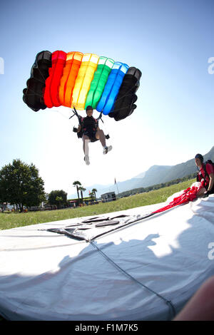 Skydiver under canopy is approaching the landing area. Hopefully she is ...