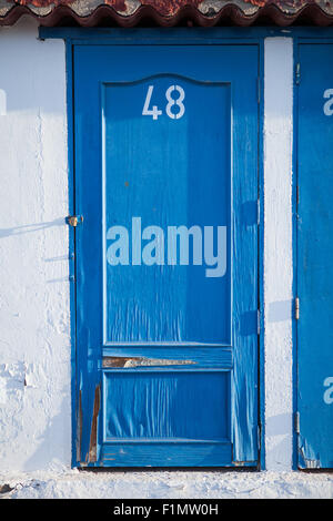 blue doors with number on white wall Stock Photo - Alamy