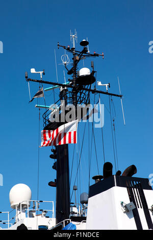 A coast guard ship docked and a mast with flags at the maritime museum ...