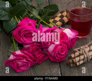 Close up tea, cookies and a bouquet of fresh tulips in bed. Breakfast ...