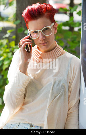 Hipster talk on mobile phone coming down stairs urban outdoors, talking ...