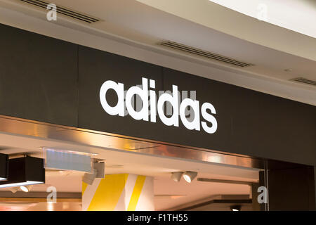 Adidas sign, logo in front of Adidas shop. Adidas is a global sports ...