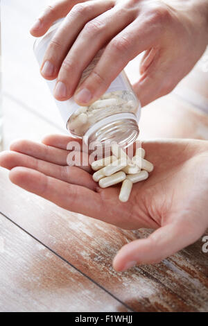 Tablets, pills, capsules, drugs pouring out of white bottle on white ...