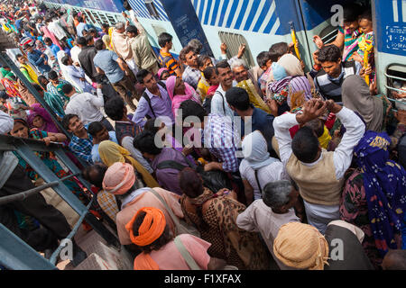 A crowd of passengers scramble to board a stationary train at the ...