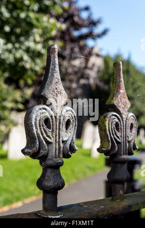An ornate metal fence surrounds a curved stone bench above an ...