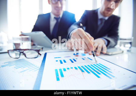 Analyzing data. Close-up of young businessman pointing on the data ...