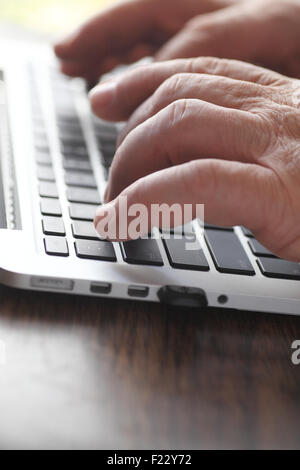 Closeup of senior man hands using laptop. Cropped side view of wrinkled ...