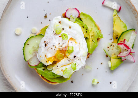 Eating toast with avocado and poached egg in a cafe Stock Photo - Alamy