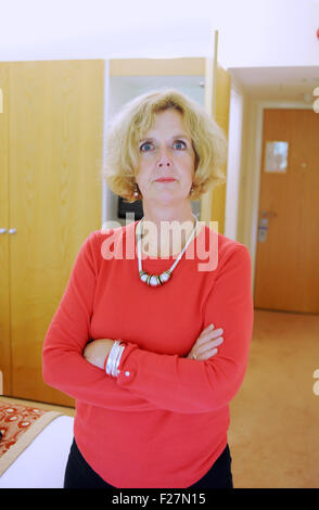 Attractive middle aged woman with folded arms emotionally posing in studio on white background ...