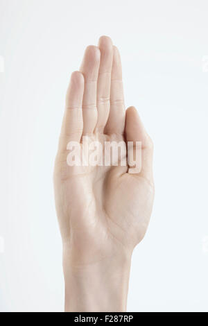 Woman making oath gesture in a city street, standing confidently ...