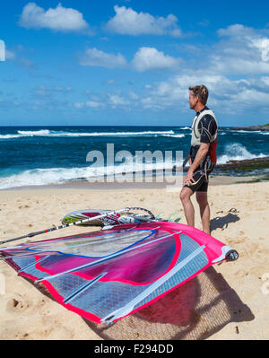 People on a beach watching a windsurfer Stock Photo - Alamy