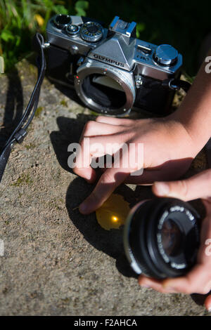 Boy Starting a Fire with a Magnifying Glass Stock Photo - Alamy