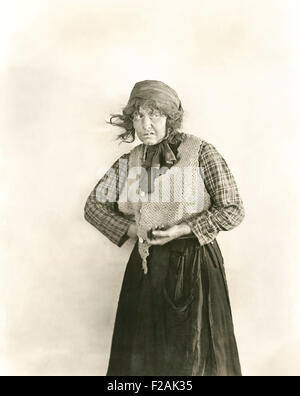 Old poor peasant woman beggar with a cane and a sack on her back ...